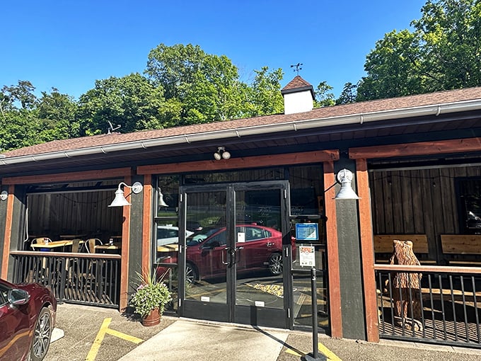 The rustic cabin exterior of Bear's Den Steakhouse promises a wilderness experience with gourmet credentials. That wooden bear statue isn't just decoration—it's a preview of coming attractions.