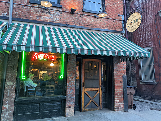The unassuming exterior of Arnold's Bar & Grill beckons with its vintage charm and green-striped awning—Cincinnati's worst-kept secret hiding in plain sight.