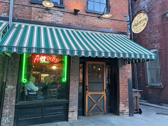 The unassuming exterior of Arnold's Bar & Grill beckons with its vintage charm and green-striped awning—Cincinnati's worst-kept secret hiding in plain sight.