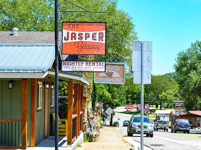 The Jasper Getaway sign welcomes visitors with a splash of orange against the Ozark backdrop – small-town charm with big-time views awaits.
