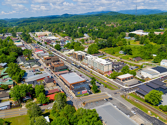 Blue Ridge unfolds like a storybook mountain town from above, its charming streets nestled among endless rolling green hills that seem to stretch into forever.