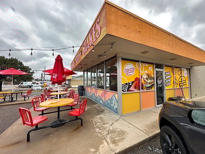 The sunshine-yellow exterior of Big Sky Burger stands out like a beacon for hungry travelers, promising simple pleasures with its no-nonsense "BURGERS • FRIES • SHAKES" declaration.