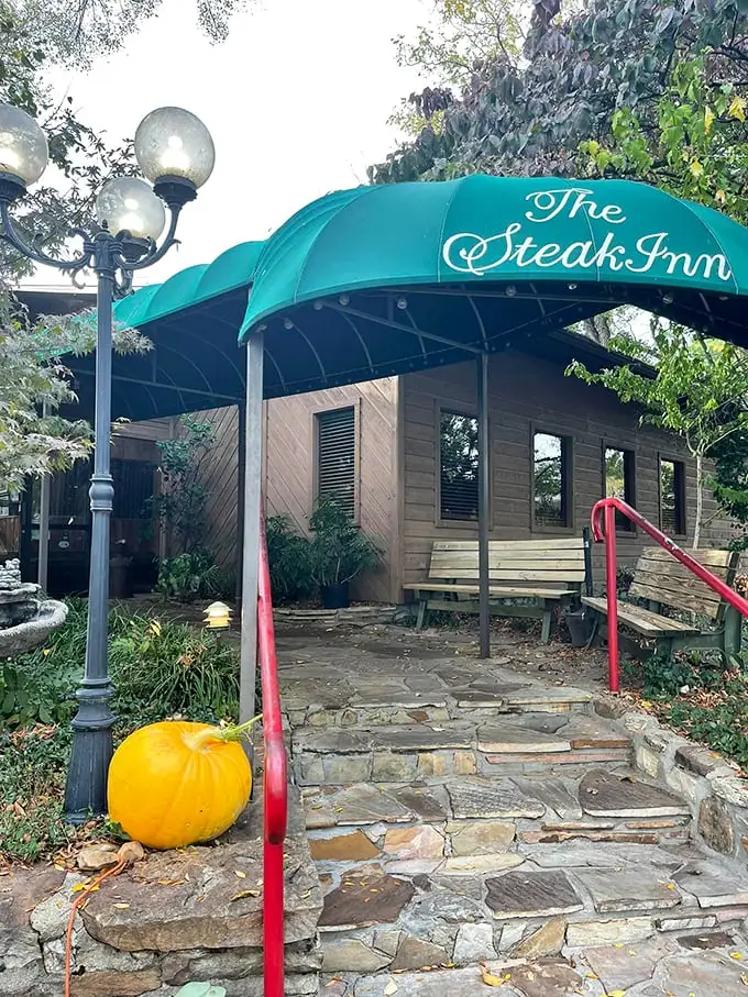 The rustic cabin exterior of The Steak Inn emerges from the Ozark forest like a carnivore's mirage, promising chargrilled treasures within.