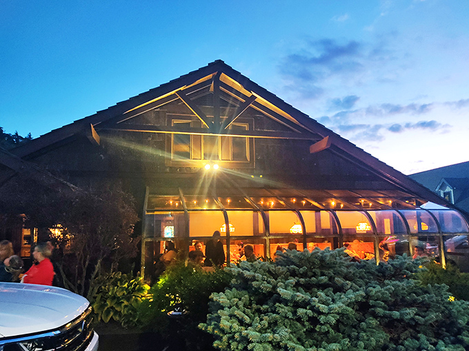 The iconic Peddler sign welcomes hungry travelers with its warm glow and glass-enclosed fire feature—a beacon of promised culinary delights in Boone's mountain landscape. 