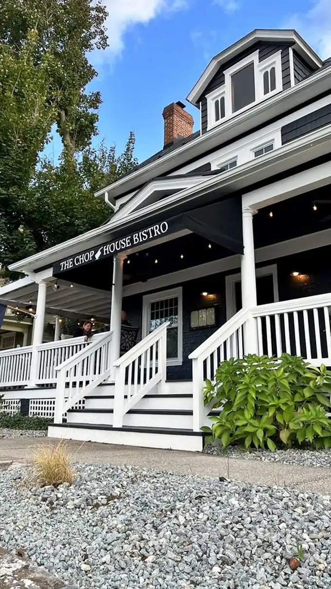 The navy blue colonial exterior of Chop House Bistro stands like a culinary lighthouse in Luray, beckoning hungry travelers with its classic charm and welcoming porch.