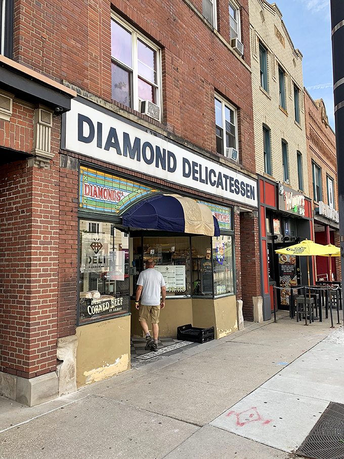 The unassuming storefront of Diamond Deli beckons with its classic brick façade and cheerful red umbrellas—sandwich paradise hiding in plain sight.