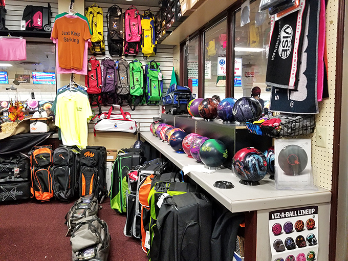 The pro shop wall—a rainbow of possibilities where the right ball promises to transform your awkward gutter balls into majestic strikes.