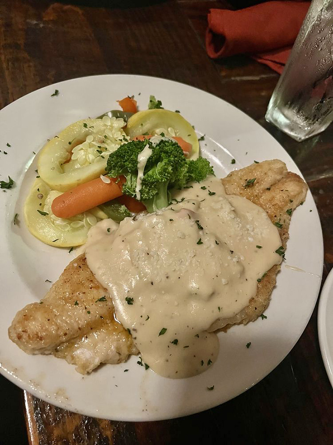 Farm-raised catfish wearing a formal coat of seasoning and swimming in sauce—it's dressed up more elegantly than I am, and with better taste.