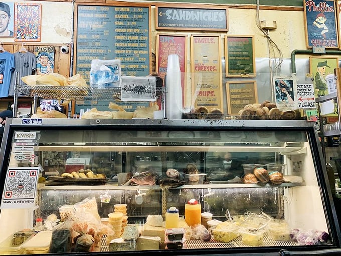 Behind this glass lies treasure more valuable than gold—cheeses, meats, and spreads awaiting their destiny between two perfect slices of bread.