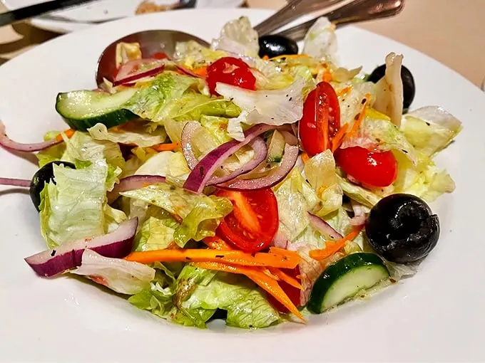 A house salad that actually deserves respect. Crisp vegetables, punchy olives, and that vinaigrette—proof that simple ingredients handled properly create magic.