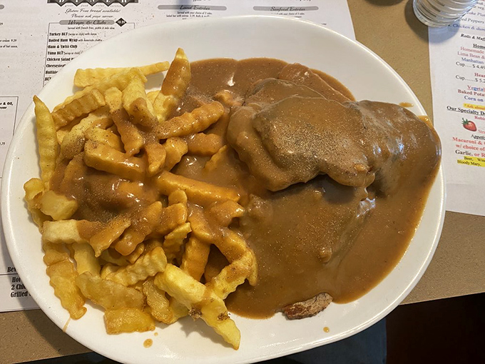 The open-faced hot beef sandwich: where gravy flows like a savory waterfall over meat and fries, creating a knife-and-fork masterpiece.