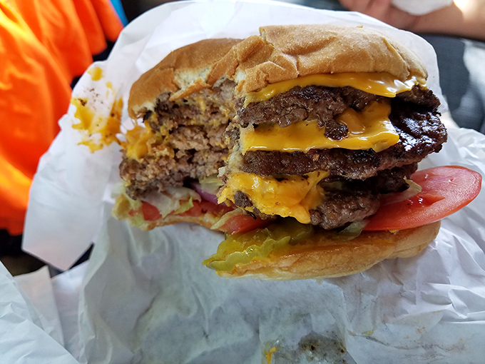 This cross-section reveals the burger's magnificent strata—each layer of beef, cheese, and fresh veggies in perfect harmony.