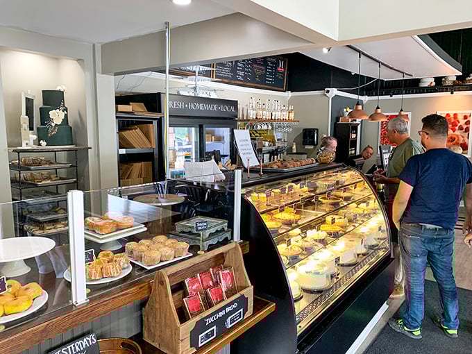 Where pastry pilgrims gather to worship at the altar of butter and sugar. The glass case serves as both barrier and window to temptation.