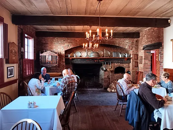 The fireplace isn't just for warmth—it's the heart of this dining room where modern conversations echo those from two centuries ago.