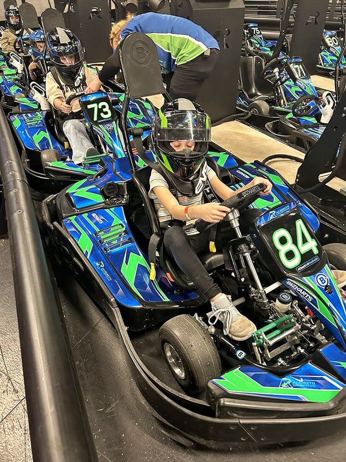 Staff members ensure young racers are properly secured—safety harnesses now, therapy for speed addiction later.