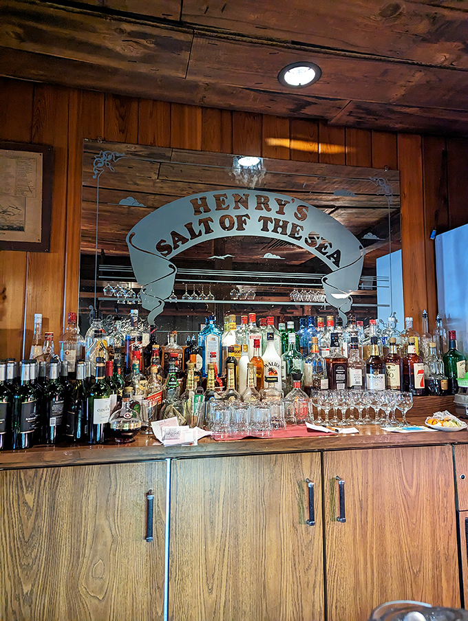 The bar at Henry's doesn't just serve drinks—it serves maritime history under glass, with the restaurant's name proudly displayed like a ship's banner.