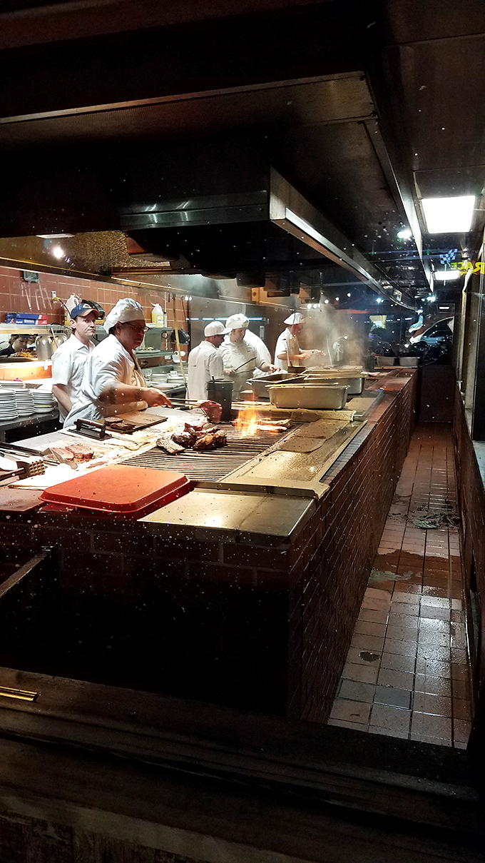 The open kitchen isn't theater—it's transparency. Chefs in white working the grill with practiced precision, creating the smoky magic that keeps people coming back decade after decade.