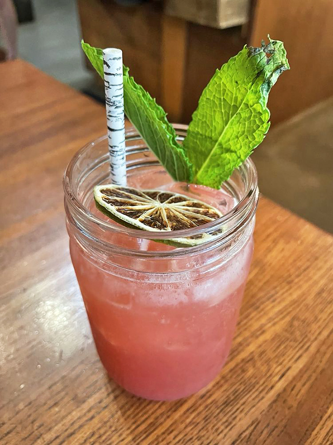 This isn't just a pretty pink drink—it's summer in a mason jar, complete with mint leaves standing tall like they own the place.