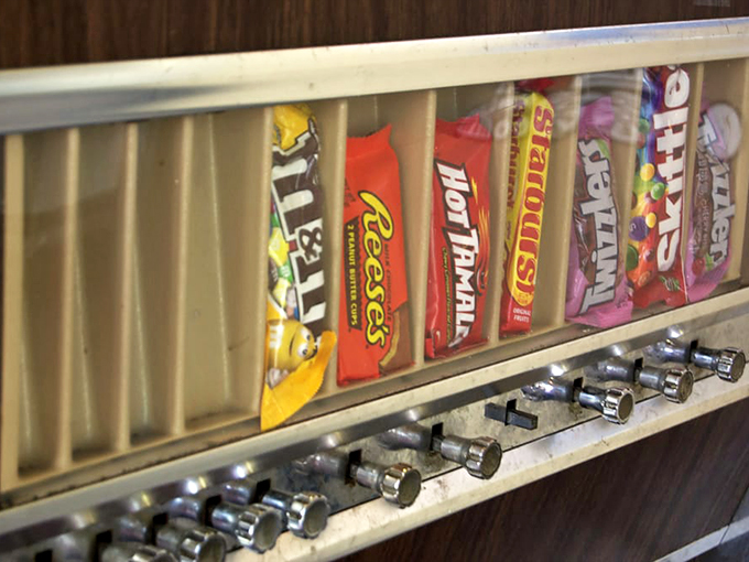 Candy dreams line up behind glass—M&Ms, Reese's, and Hot Tamales waiting patiently to complete your meal with a sweet finale.