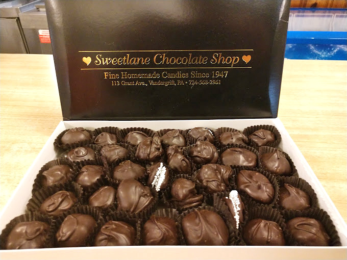 A box of chocolates is a promise kept – each brown beauty nestled in its paper cup like a precious artifact of happiness.