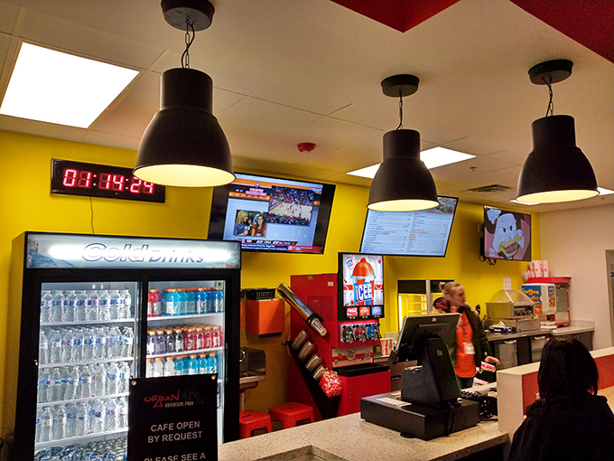The café's bright yellow walls and cold drink selection stand ready to rehydrate warriors returning from trampoline battles.