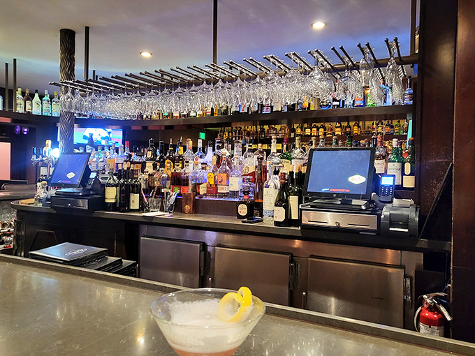 A bar stocked like a liquid library of possibilities. Those hanging glasses await their moment in the spotlight of your evening.