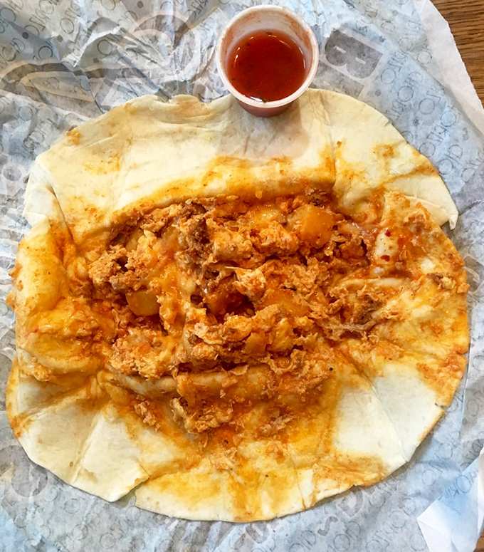 Breakfast in its most honest form—a flour tortilla embracing scrambled eggs and chorizo like they're long-lost friends finally reunited after years apart.