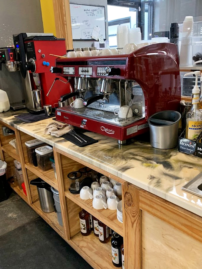 The gleaming red espresso machine stands ready for duty like a Ferrari in a garage – powerful, beautiful, and dedicated to delivering peak performance.
