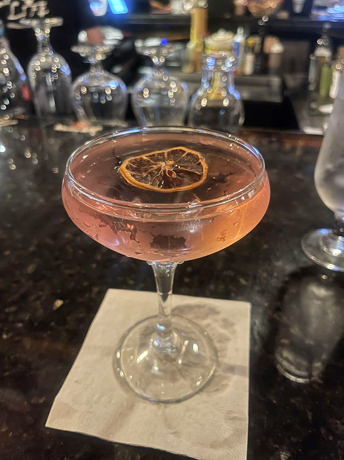 A cocktail garnished with dried citrus – proof that even the beverages here are dressed for success. Like a tiny edible work of art.