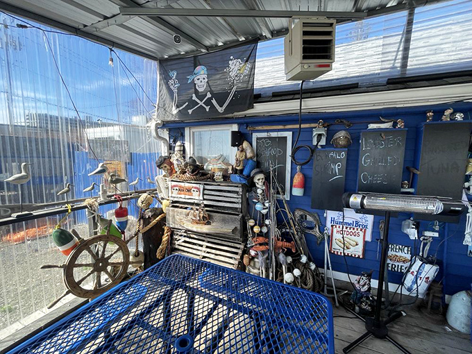 Where nautical dreams meet seafood reality—this covered seating area with its ship's wheel and pirate flag promises adventure with every meal.