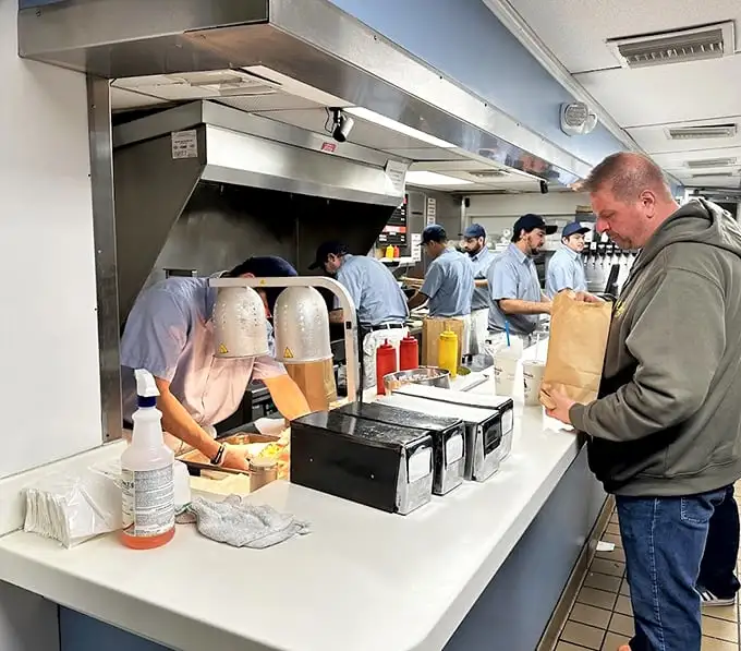 The customer's anticipation is palpable—that moment before the first bite when life's problems temporarily cease to exist.