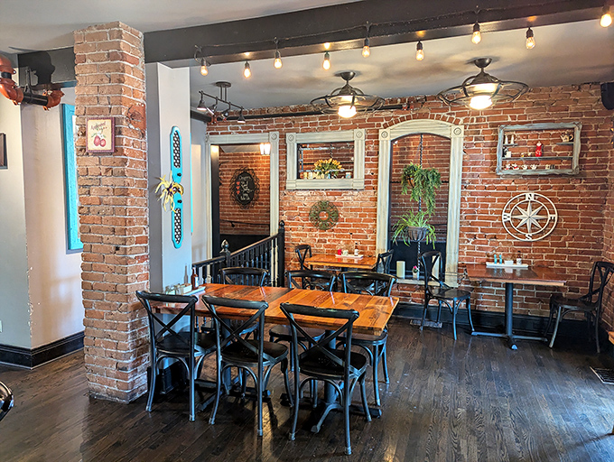 The dining room balances rustic charm with urban sophistication—brick walls, wooden tables, and string lights create an atmosphere as comforting as the food.