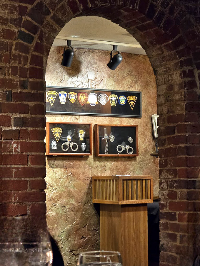Police patches and handcuffs displayed under brick arches – a tasteful nod to the building's past that adds character without crossing into kitsch.