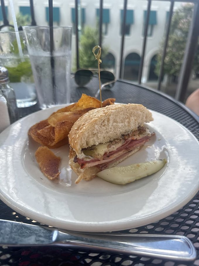 This muffuletta sandwich on the patio tells you it's not just about what's inside (though that's magnificent)—it's about taking your time with good food.