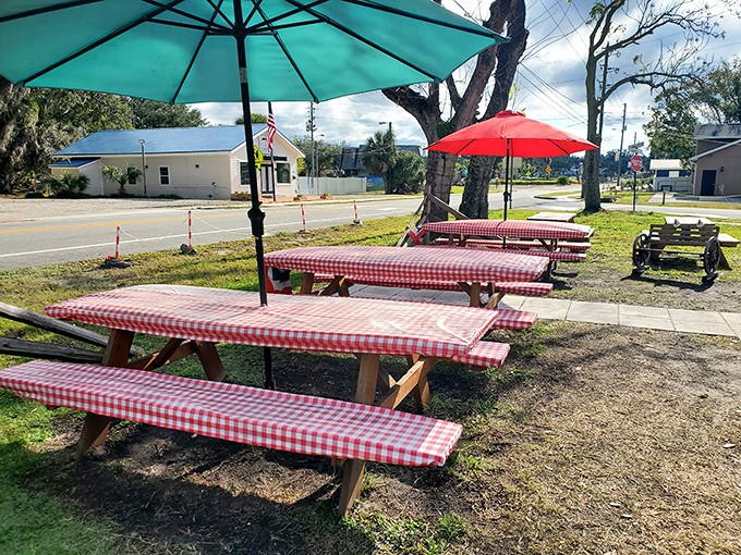 Red-checkered tables under umbrellas create that perfect casual vibe where memories are made and sauce-stained shirts become badges of honor.