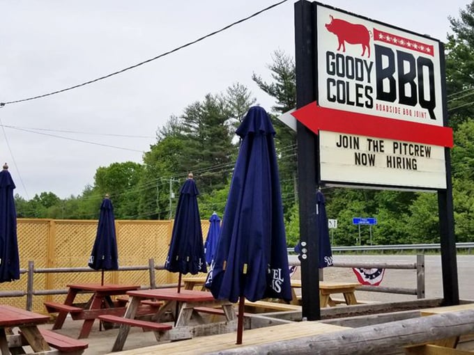 Outdoor picnic tables stand ready for warmer days, while the sign makes it clear—this isn't just a restaurant, it's a joining of the barbecue faithful.