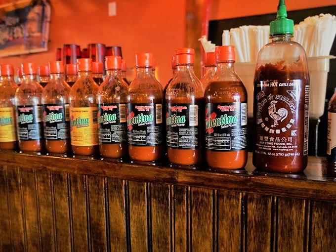 The hot sauce lineup stands ready like spicy soldiers, each bottle offering different degrees of heat for the brave and the bold.