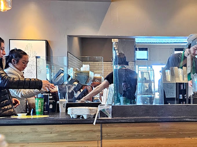 Behind the scenes at Mel's, where the magic happens – staff moving with practiced efficiency while customers perch at the counter, waiting for their slice of diner heaven.
