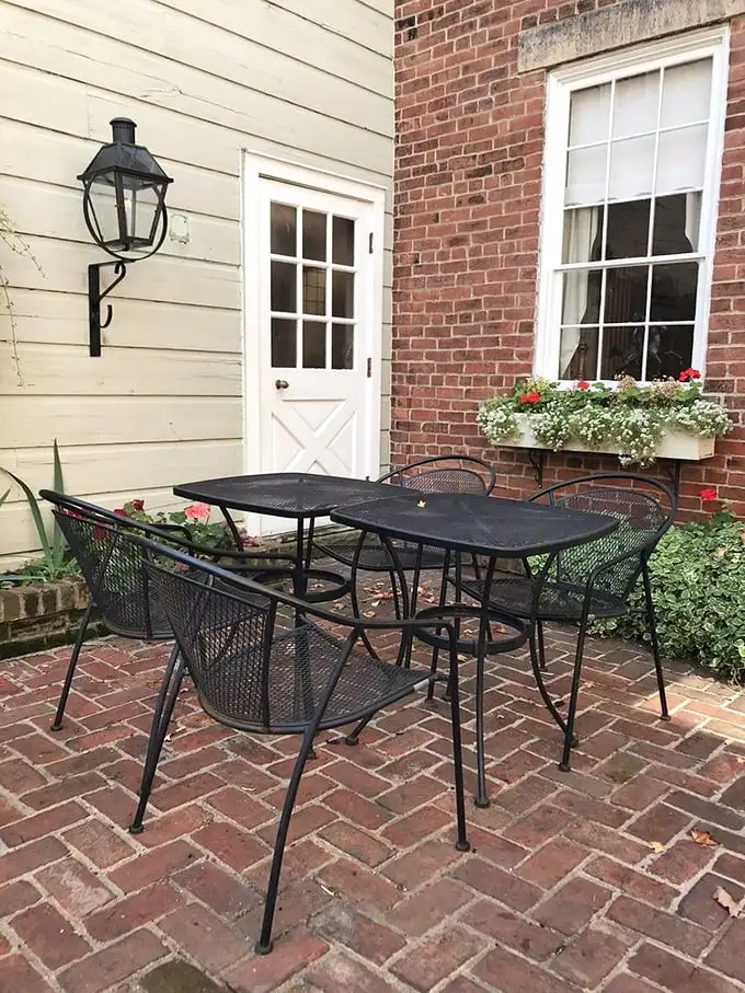Al fresco dining with a side of history—this brick patio offers a peaceful retreat where flowers and architecture create a perfect outdoor sanctuary.