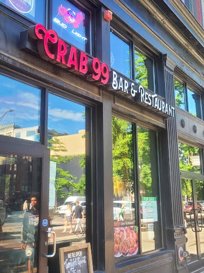 Daylight reveals Crab 99's urban habitat—a sleek storefront where the red sign serves as a beacon for downtown lunchers seeking seafood salvation.