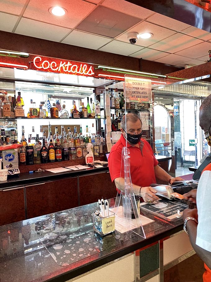 Behind that bar is where liquid magic happens. The neon "Cocktails" sign isn't just decoration—it's a promise of good times ahead.