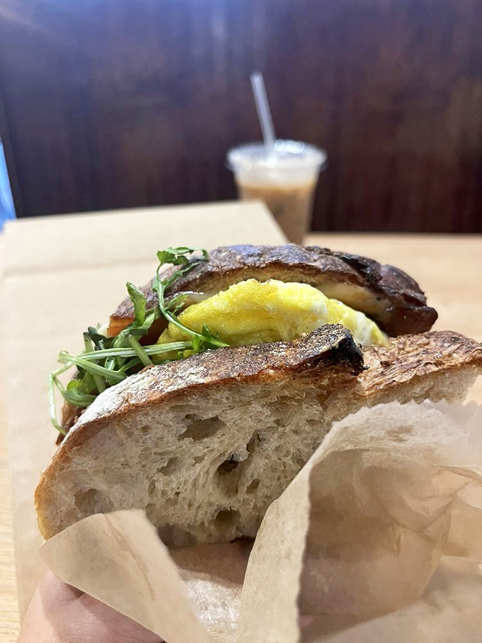 Breakfast architecture at its finest—layers of egg, greens, and bread creating the morning equivalent of the Guggenheim.