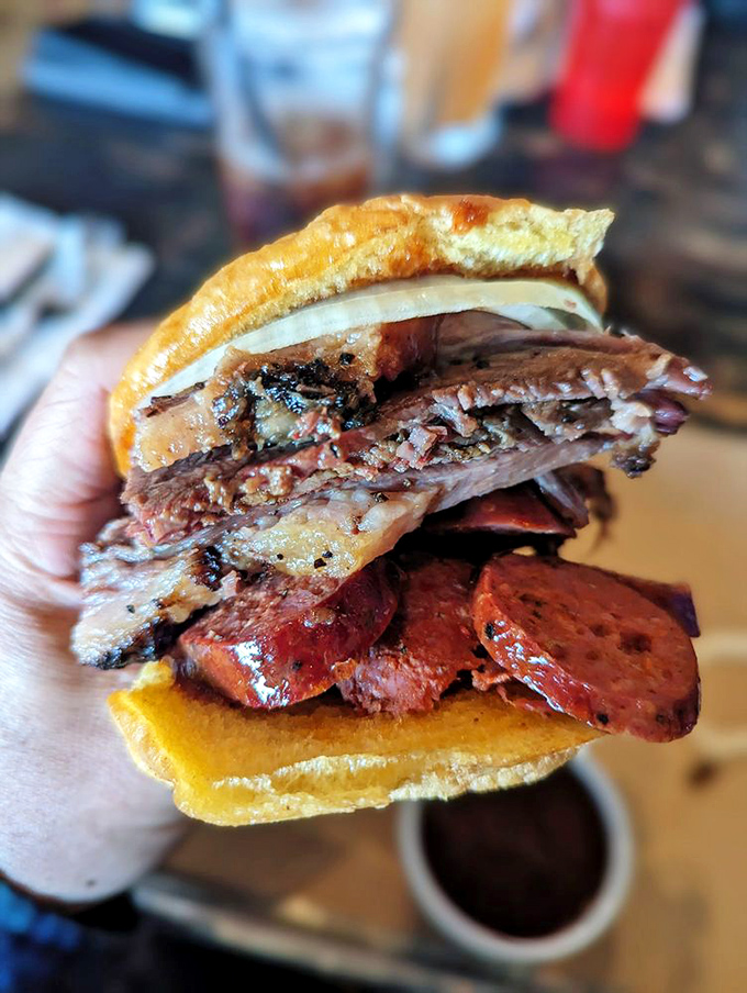 This sandwich doesn't just blur the line between lunch and religious experience—it erases it completely. The brisket and sausage combo is a Texas handshake in edible form.