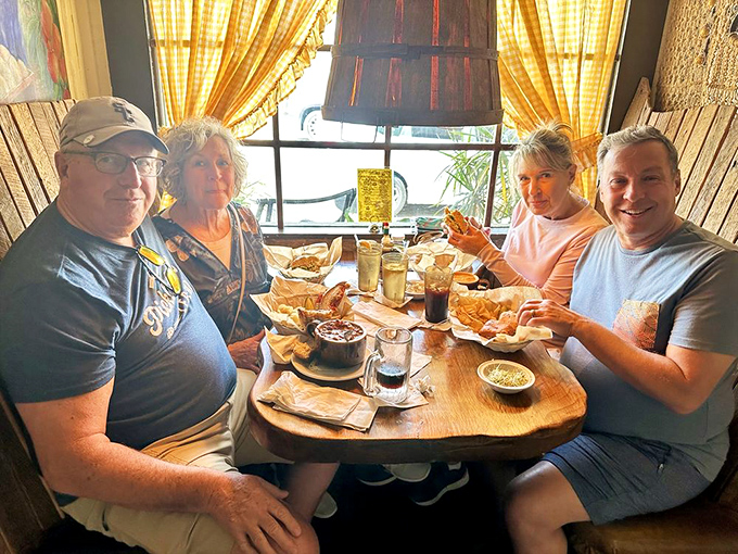 Happy diners caught in the middle of that universal moment—when the food arrives and conversation momentarily surrenders to pure enjoyment.
