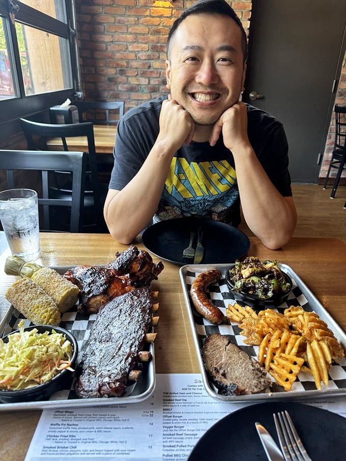 The face of pure barbecue joy—surrounded by enough smoked meat to make vegetarians reconsider their life choices.