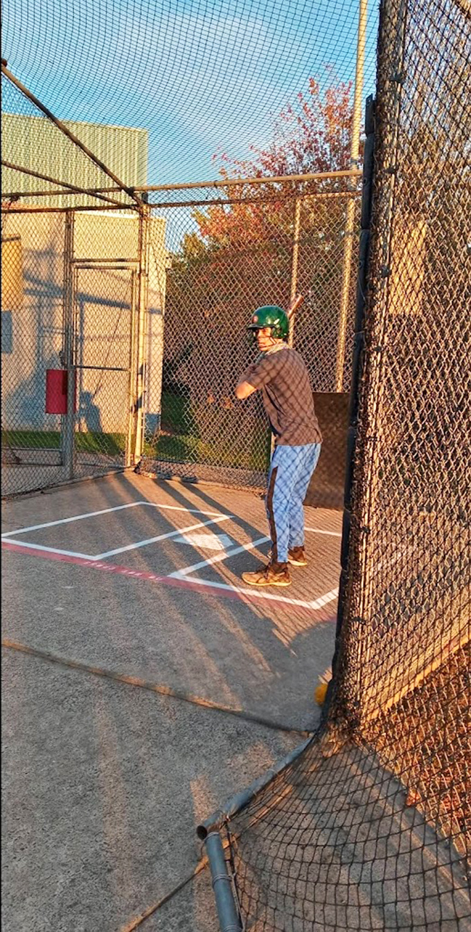 The batting cage—where baseball dreams and reality collide in a chain-link reminder that you're not quite MLB material.