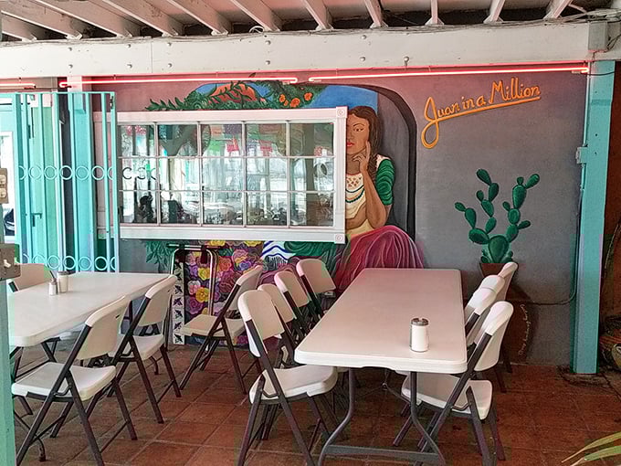 Colorful murals and simple tables create an outdoor oasis. This patio has heard more breakfast epiphanies than a philosopher's convention.