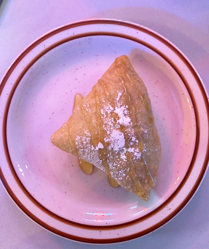 The humble sopapilla, dusted with powdered sugar and drizzled with honey, proves that the simplest desserts often create the strongest memories.