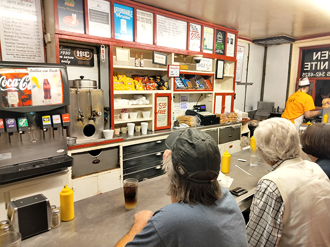 Behind the counter, where the magic happens—yellow mustard bottles standing at attention like soldiers guarding flavor territory.