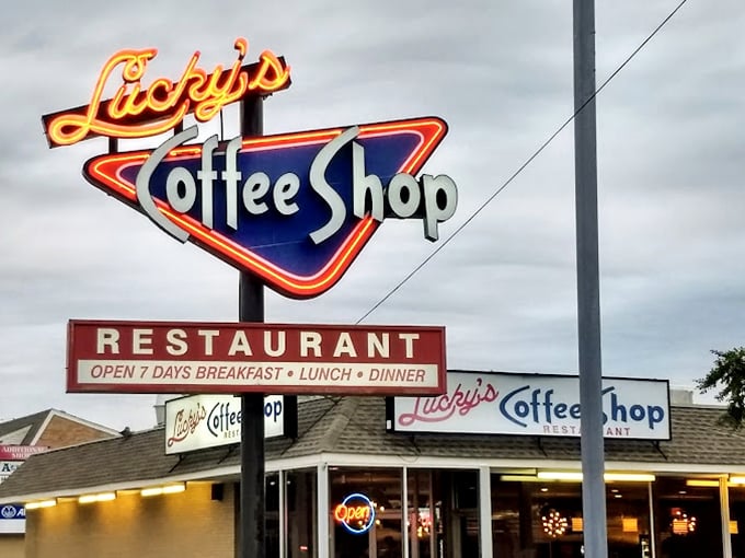 The neon sign glows like a lighthouse for hungry travelers. Three meals a day, seven days a week—Lucky's is more reliable than some family members.